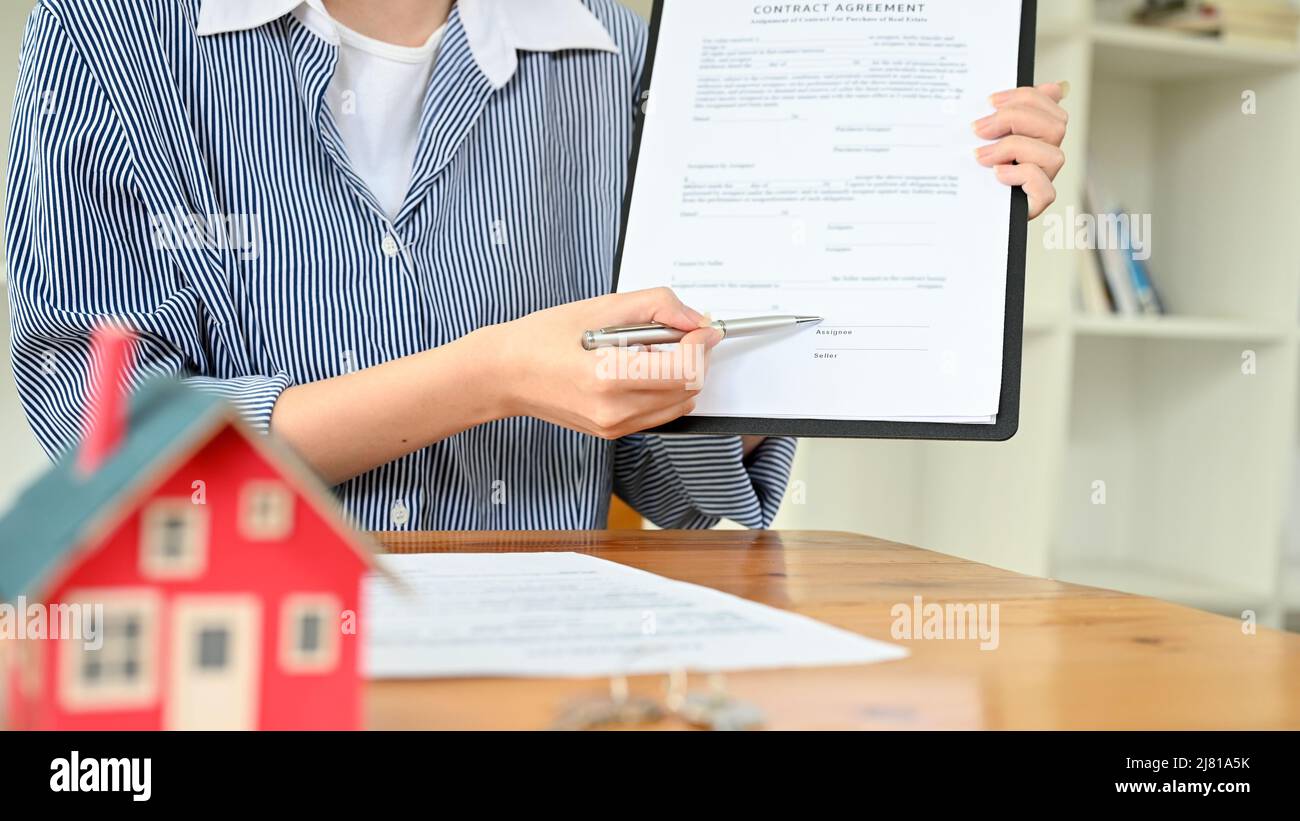 Female real estate agent showing and explaining the house rental ...