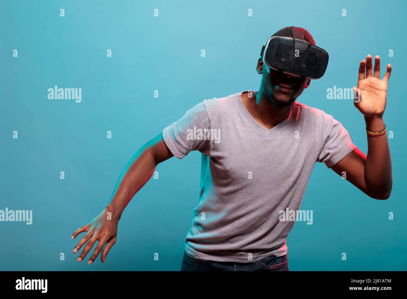 Cheerful person raising hands and playing with futuristic vr goggles to ...