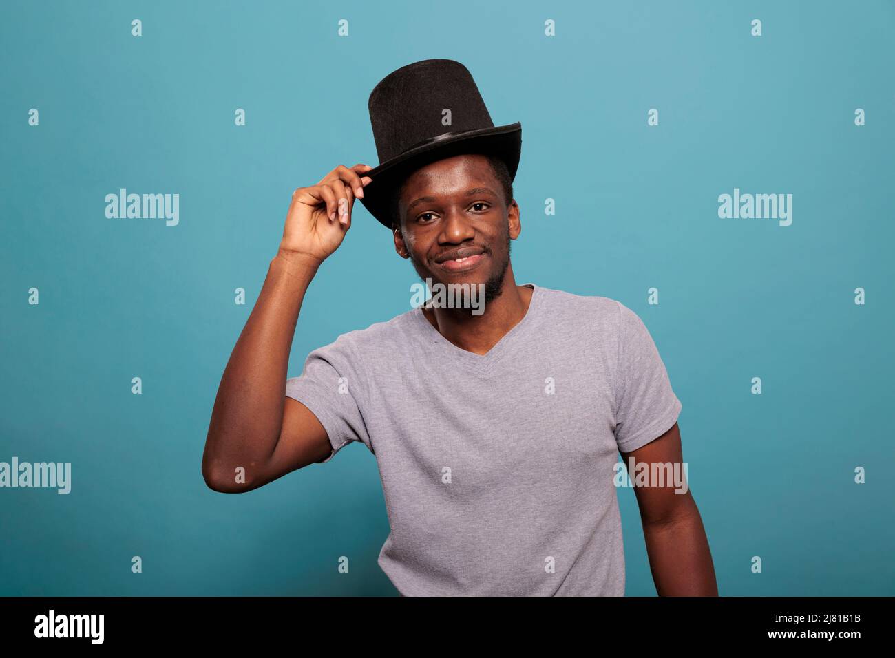 Portrait of cheerful person wearing costume top hat on head over blue ...