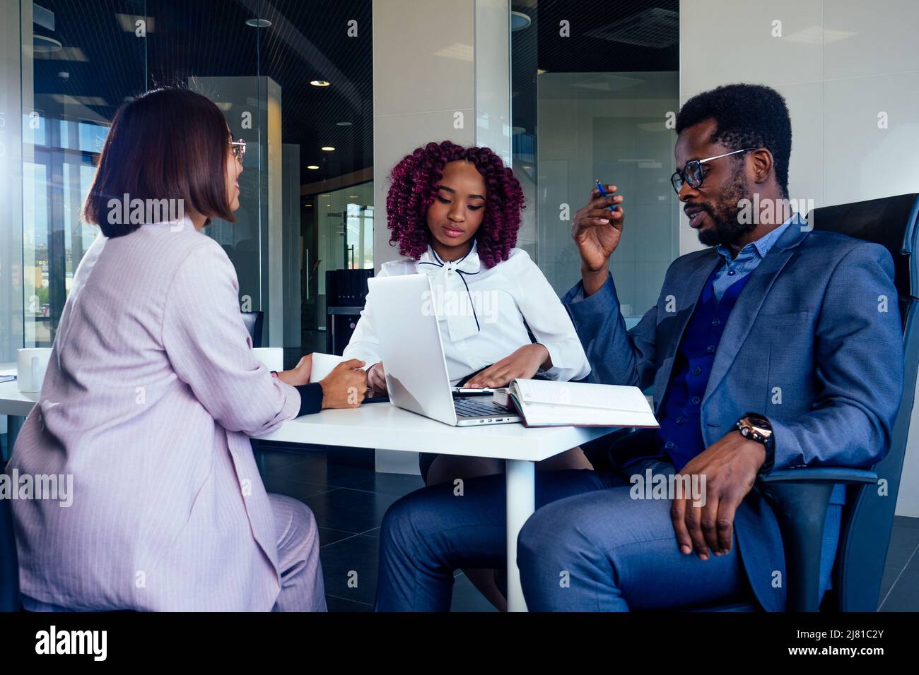 creative team of multiracial men sitting round the desk in formal ...