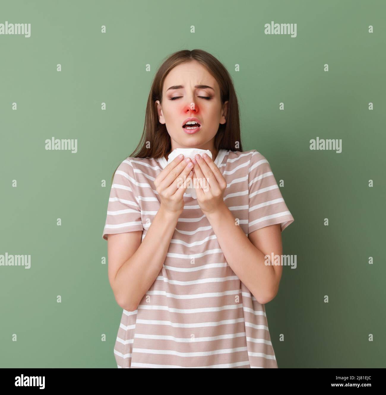 Sneezing young woman on green background. Allergy concept Stock Photo ...