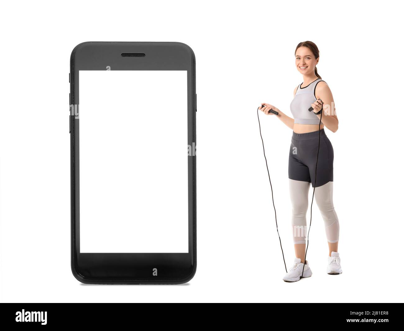 Sporty young woman with jumping rope and big smartphone with blank ...