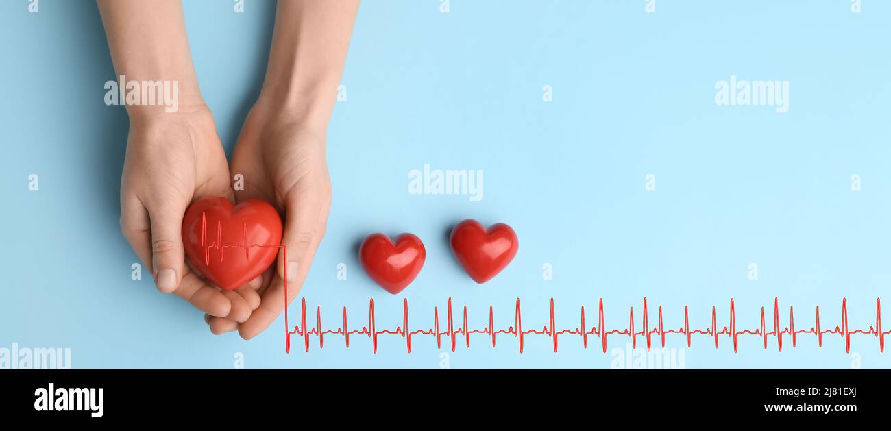 Female hands with red hearts and drawn pulse on blue background, top ...