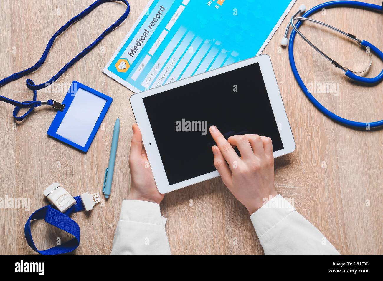 Female doctor working with tablet computer on wooden background Stock ...