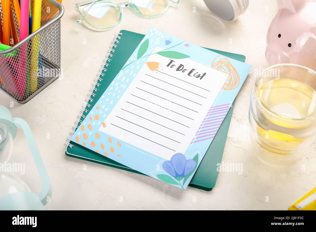 Blank to do list, notebook and glass of water on light background Stock ...