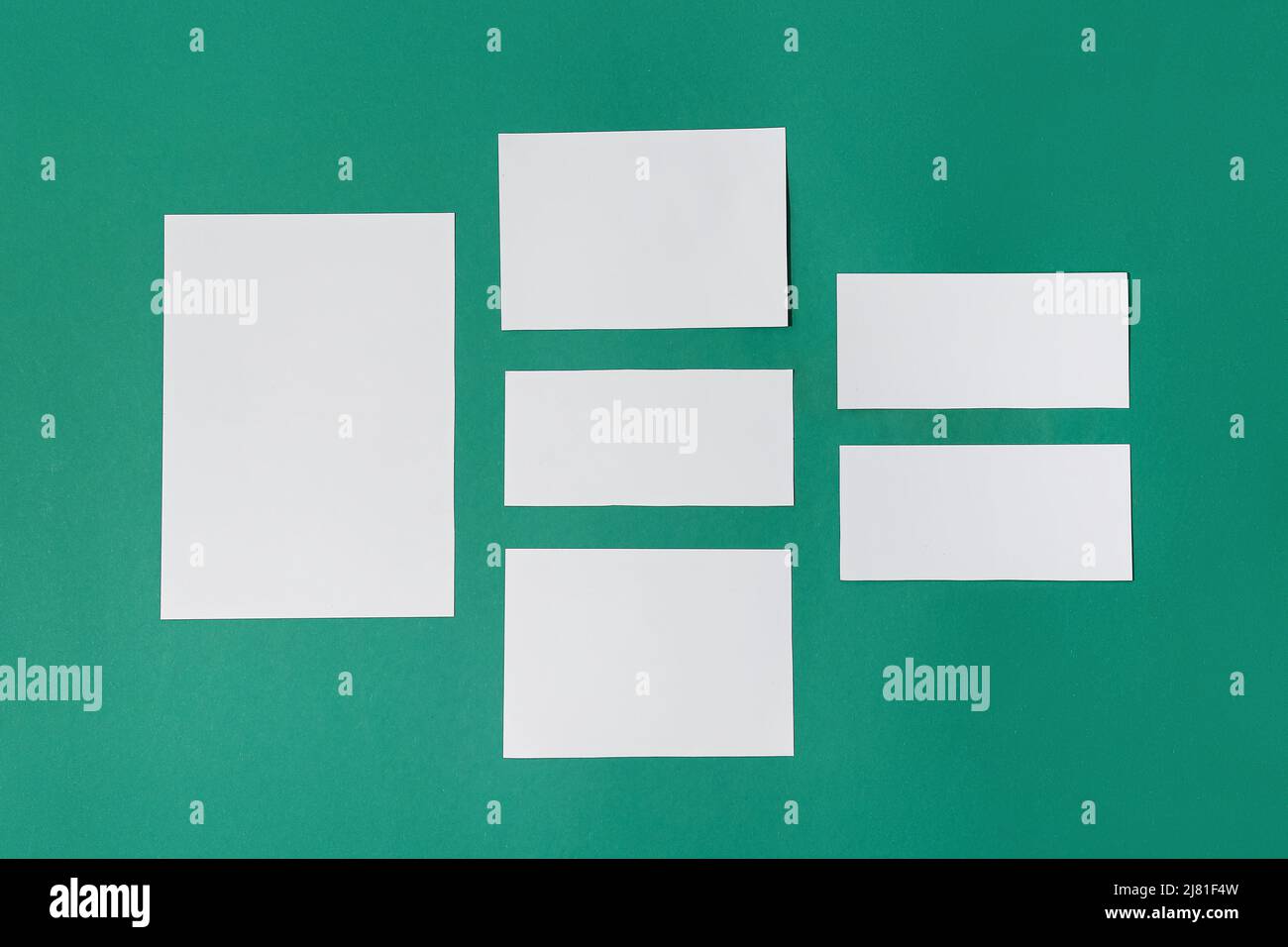 Set of blank paper sheets on green background Stock Photo - Alamy