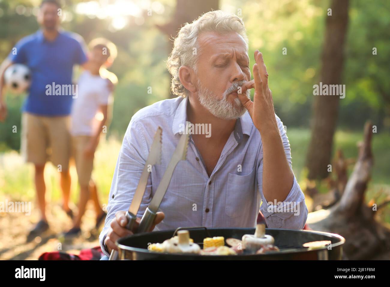 Senior man cooking food on grill at barbecue party Stock Photo - Alamy