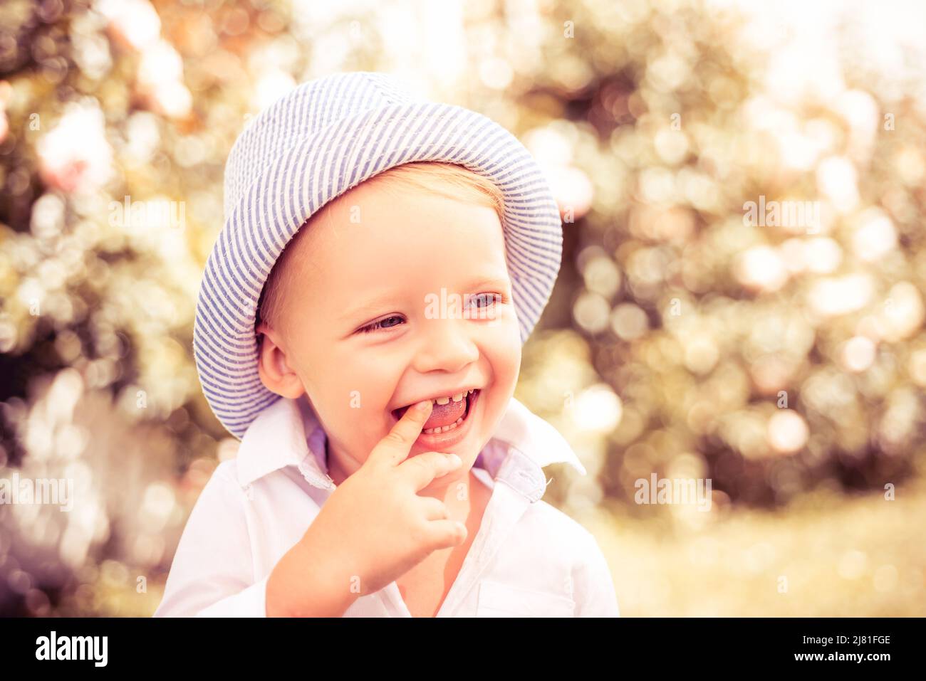 Child on the green grass in summer park. Baby face closeup. Funny ...