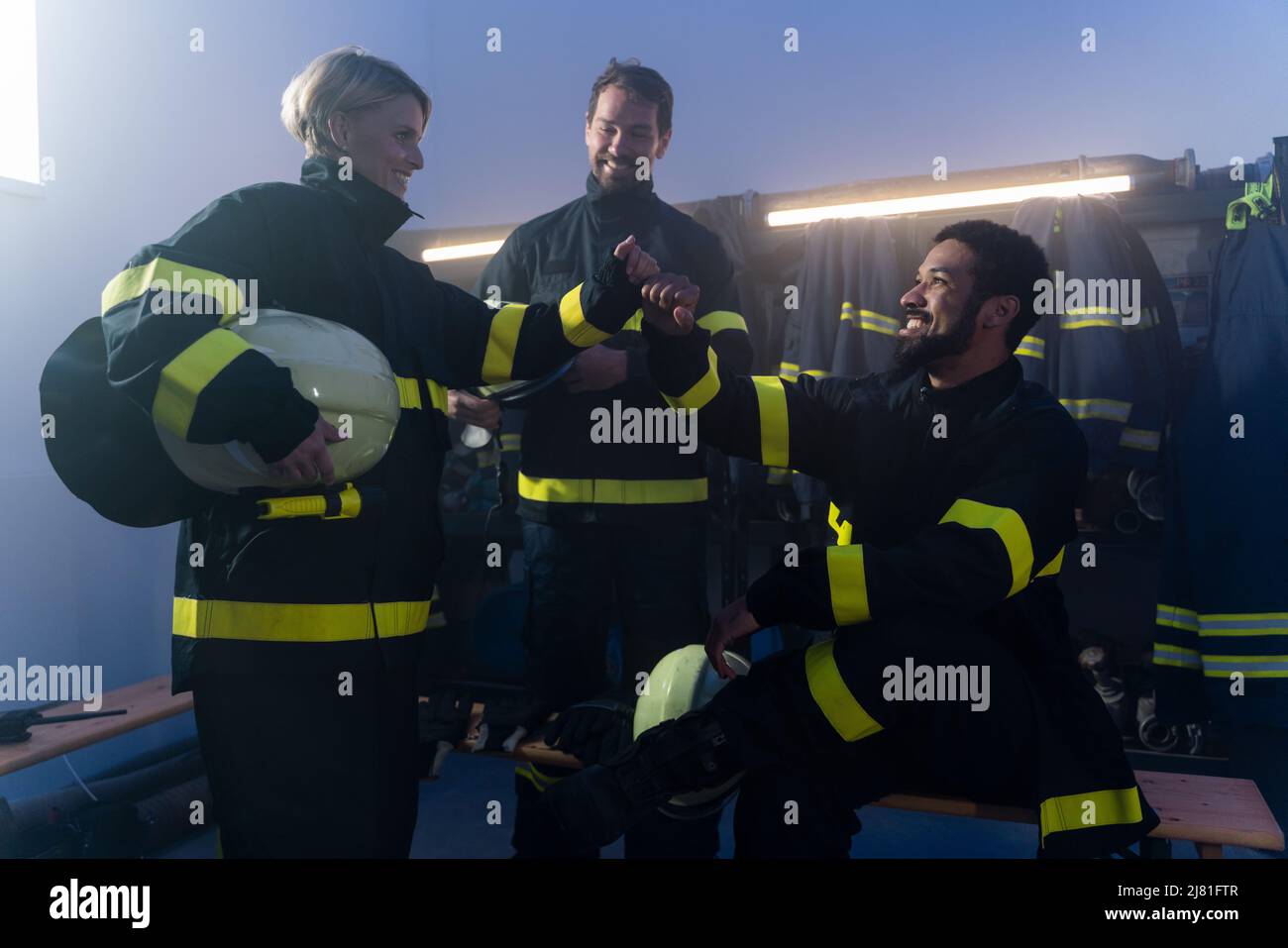 Happy firefighters men and woman talking after action indoors in fire ...
