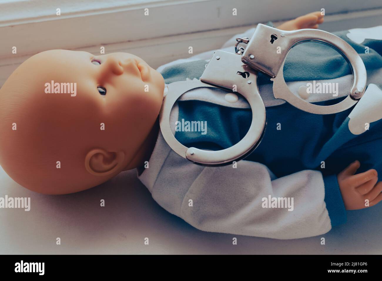 baby doll lies with handcuffs. child crime concept. High quality photo ...