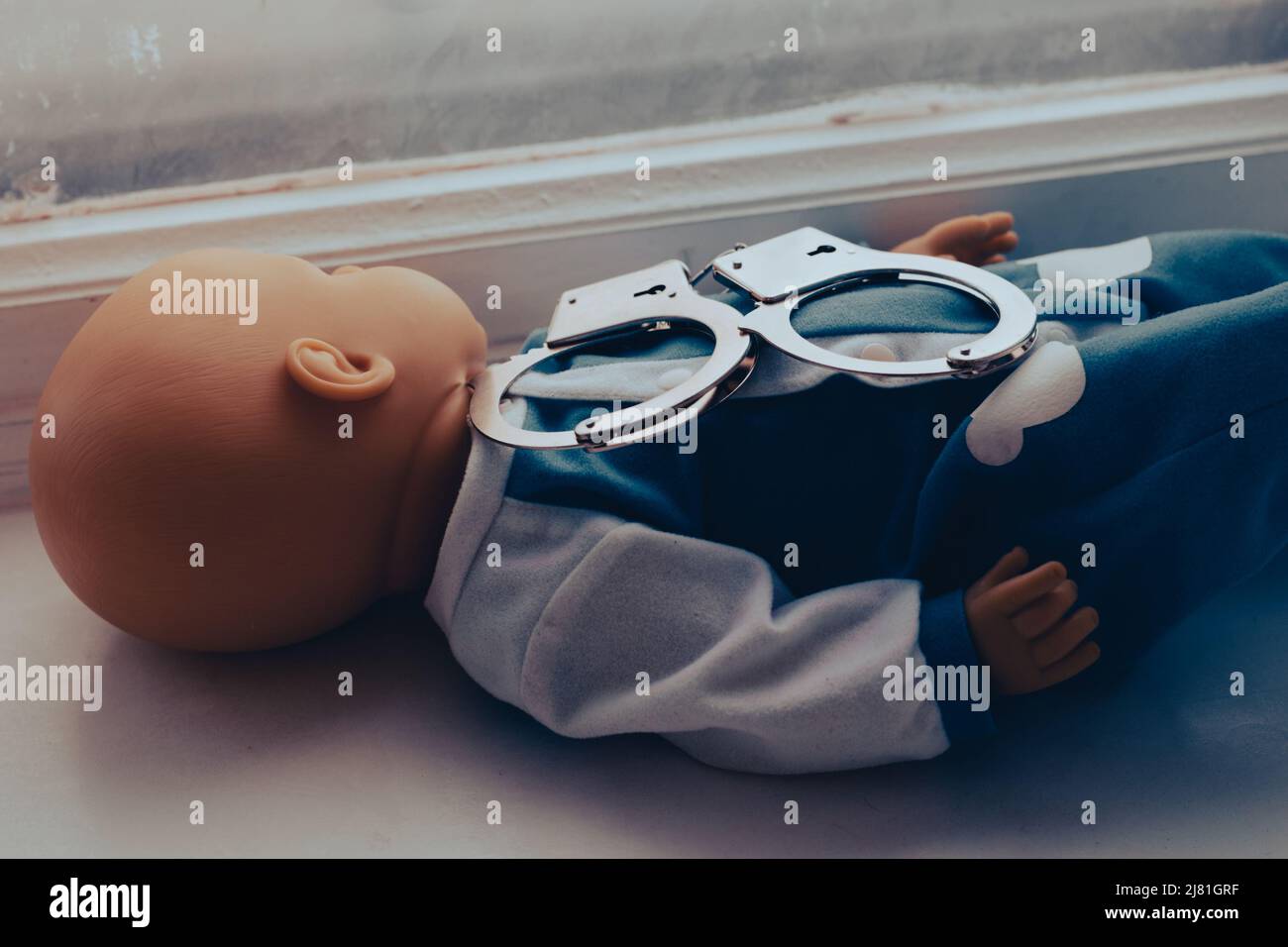 baby doll lies with handcuffs. child crime concept. High quality photo ...