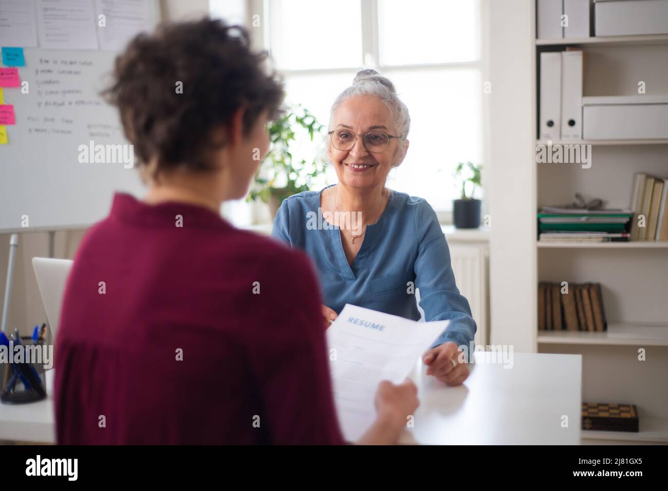 Senior woman recruiter smiling at young candidate during the job ...