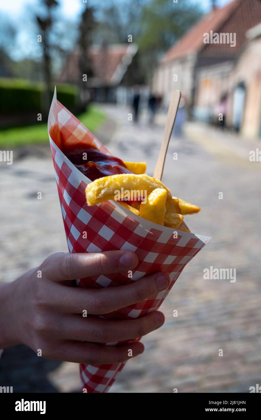 Dutch and Belgian fast and street food, child's hand with зaper bag of ...