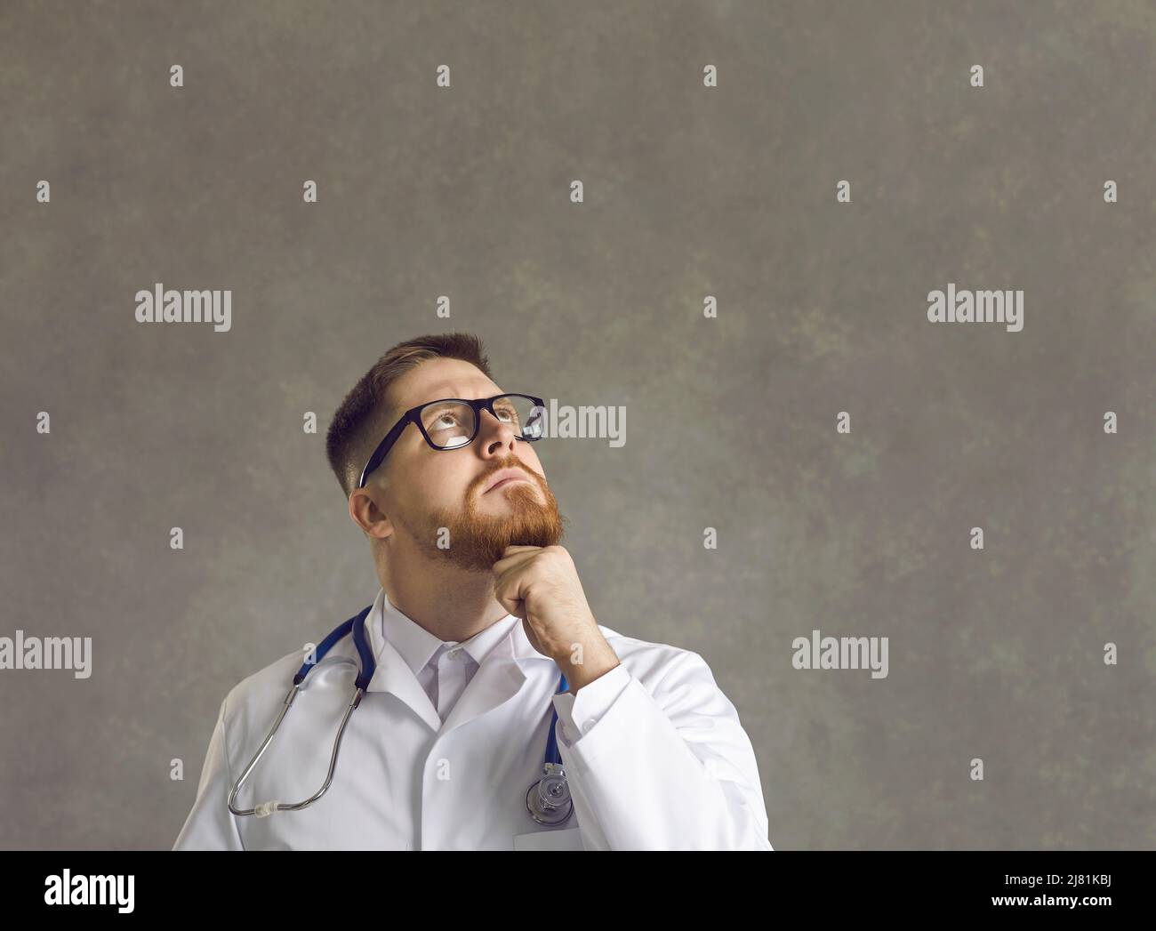 Pensive medical doctor thinking on clinical decision studio headshot ...
