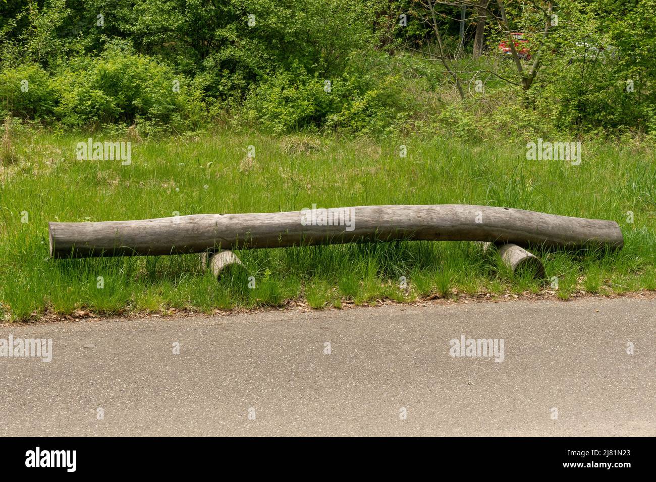 Nature bench made from a wooden trunk in the meadow Stock Photo - Alamy