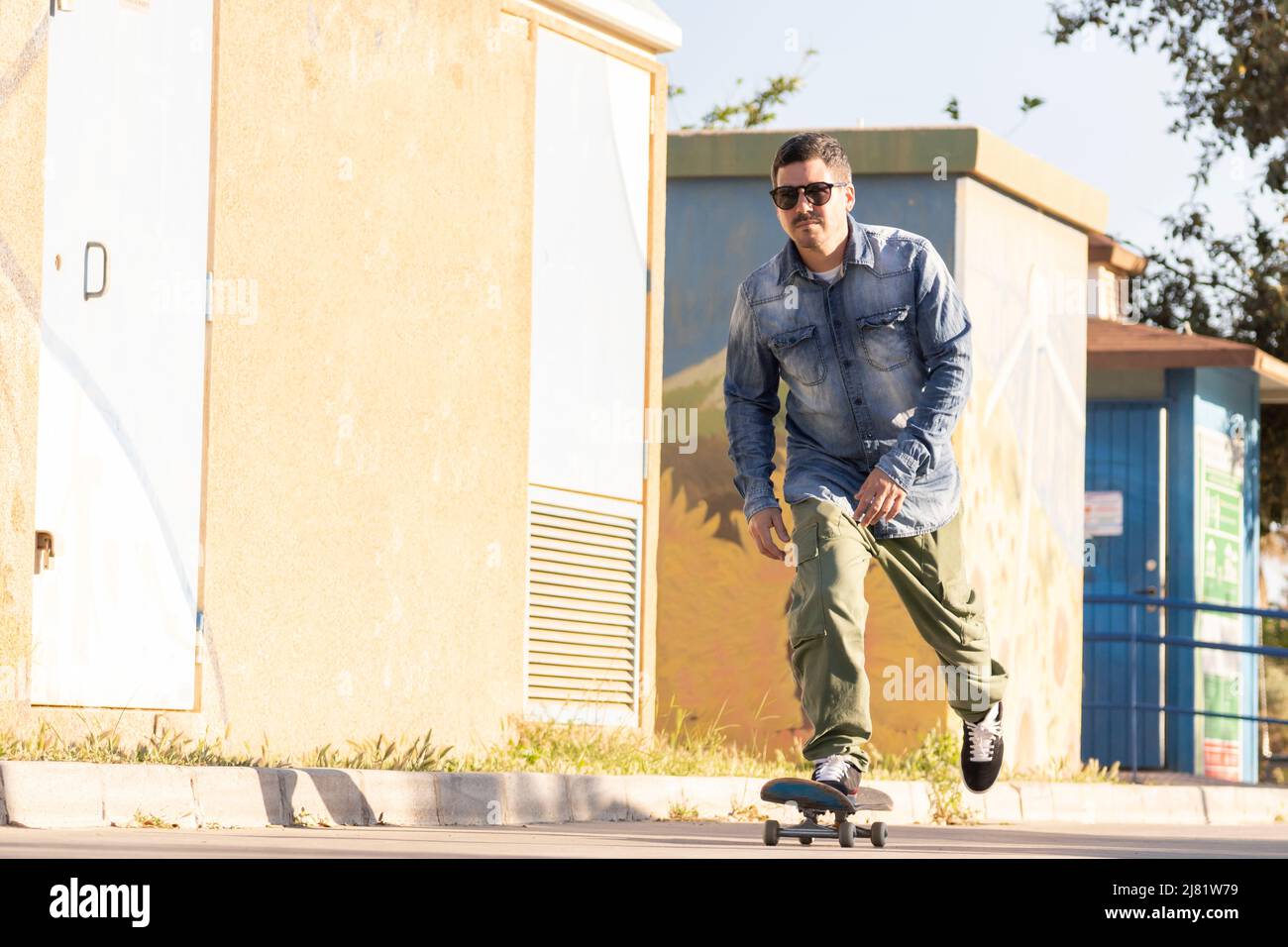 Adult man skateboarding in the city in summertime Stock Photo - Alamy