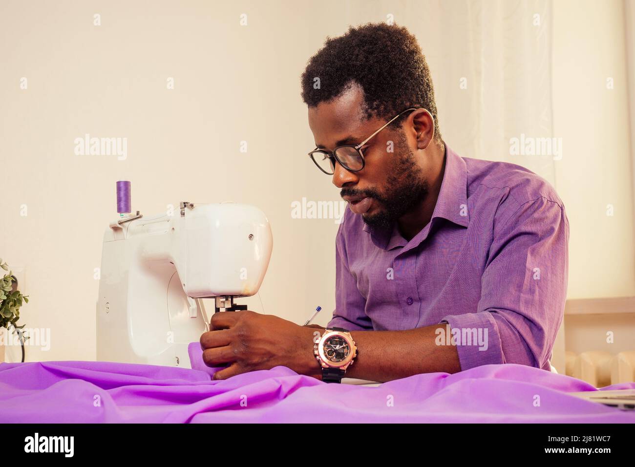 portrait of a handsome african man smiling seamstress with sewing ...