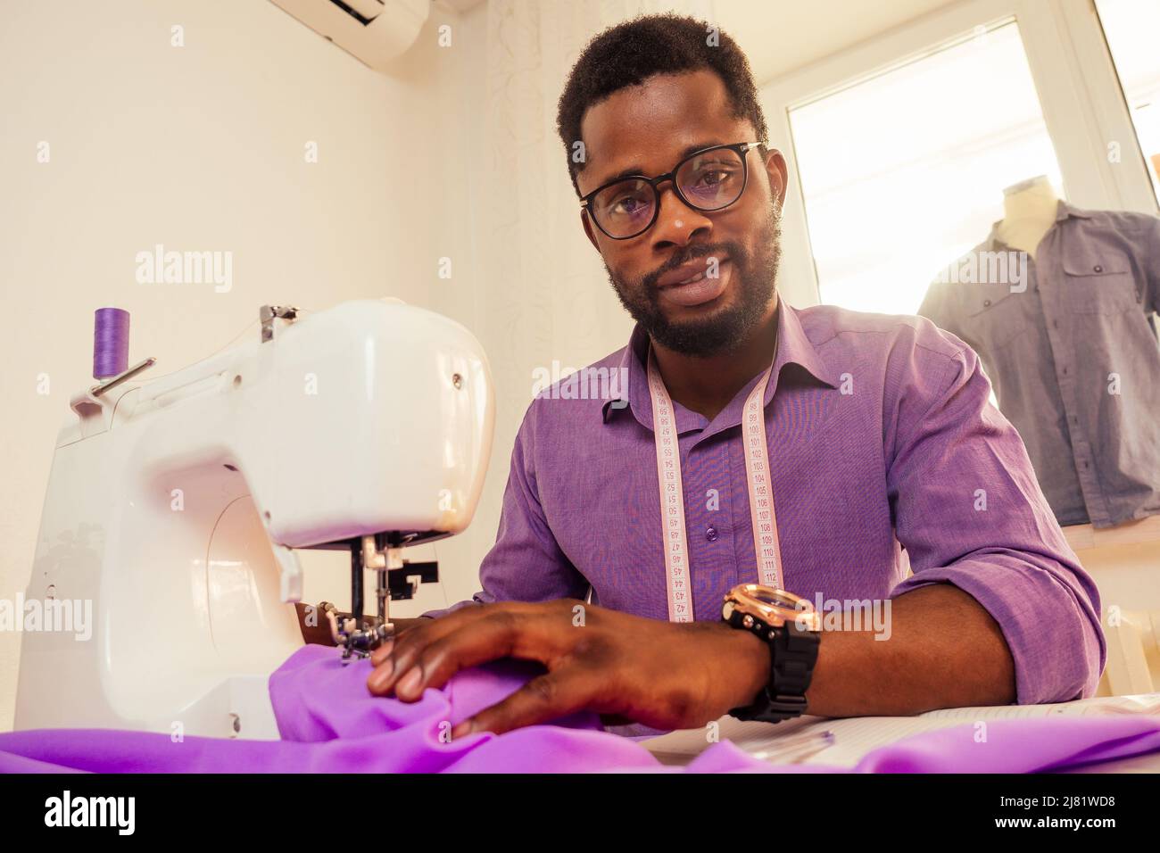 portrait of a handsome african man smiling seamstress with sewing ...