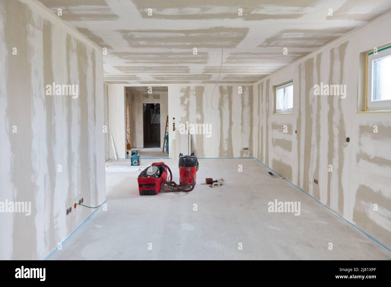 Empty living room after putty work on walls and ceiling in a new build ...