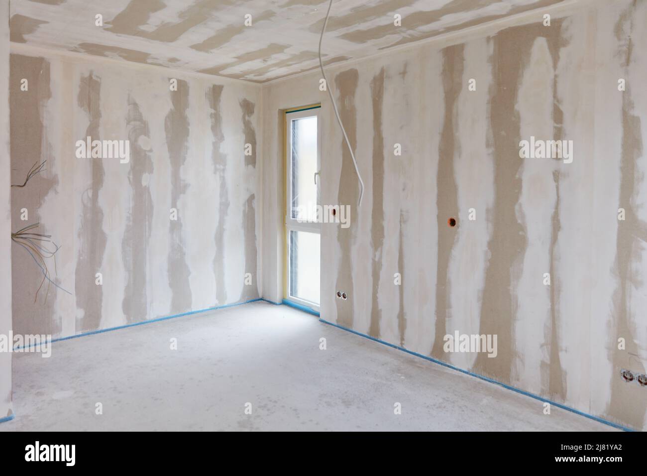 Filling work on walls and ceilings in an empty room during renovation ...