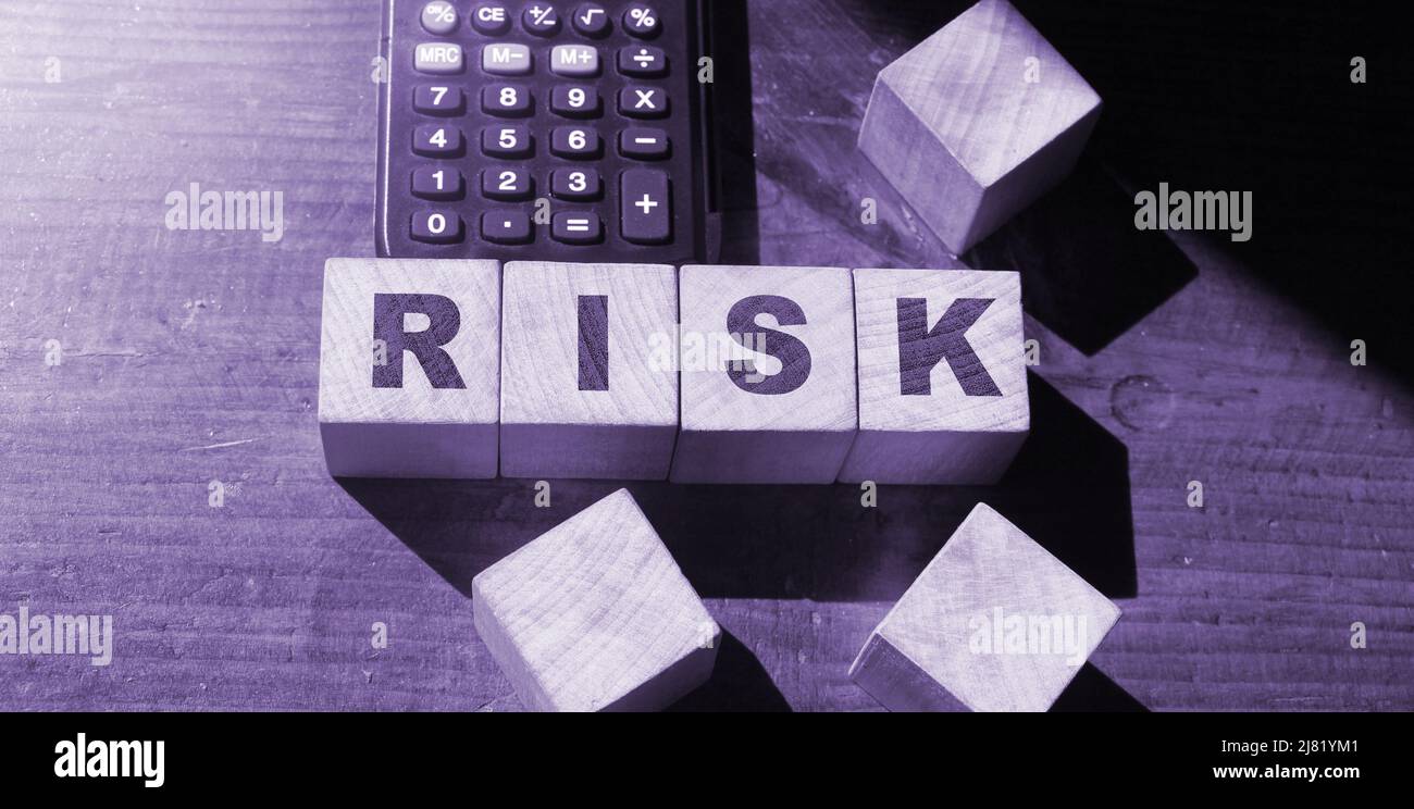 RISK word written on wooden cubes and calculator. Financial risk ...