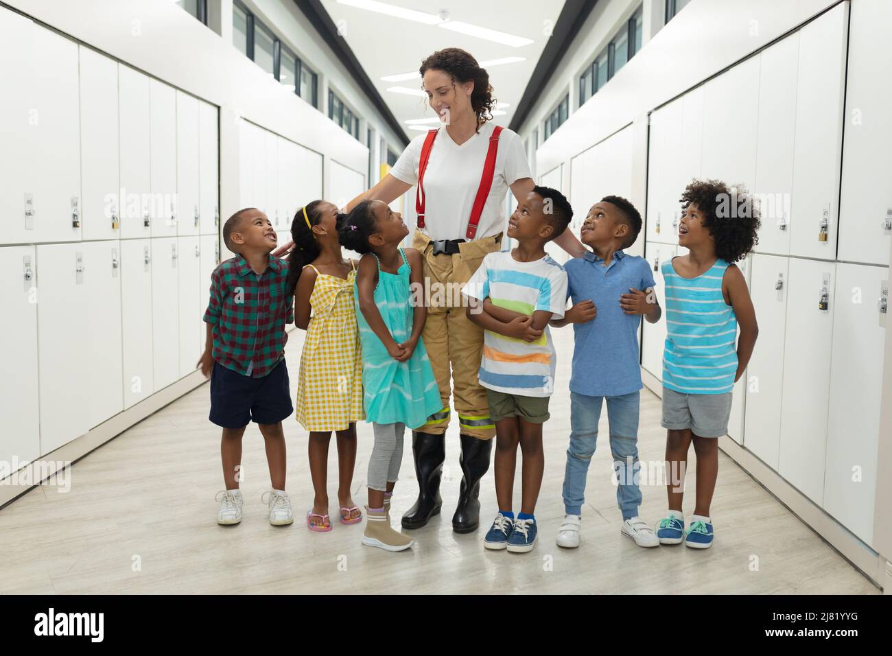 Smiling caucasian young female teacher with african american elementary ...