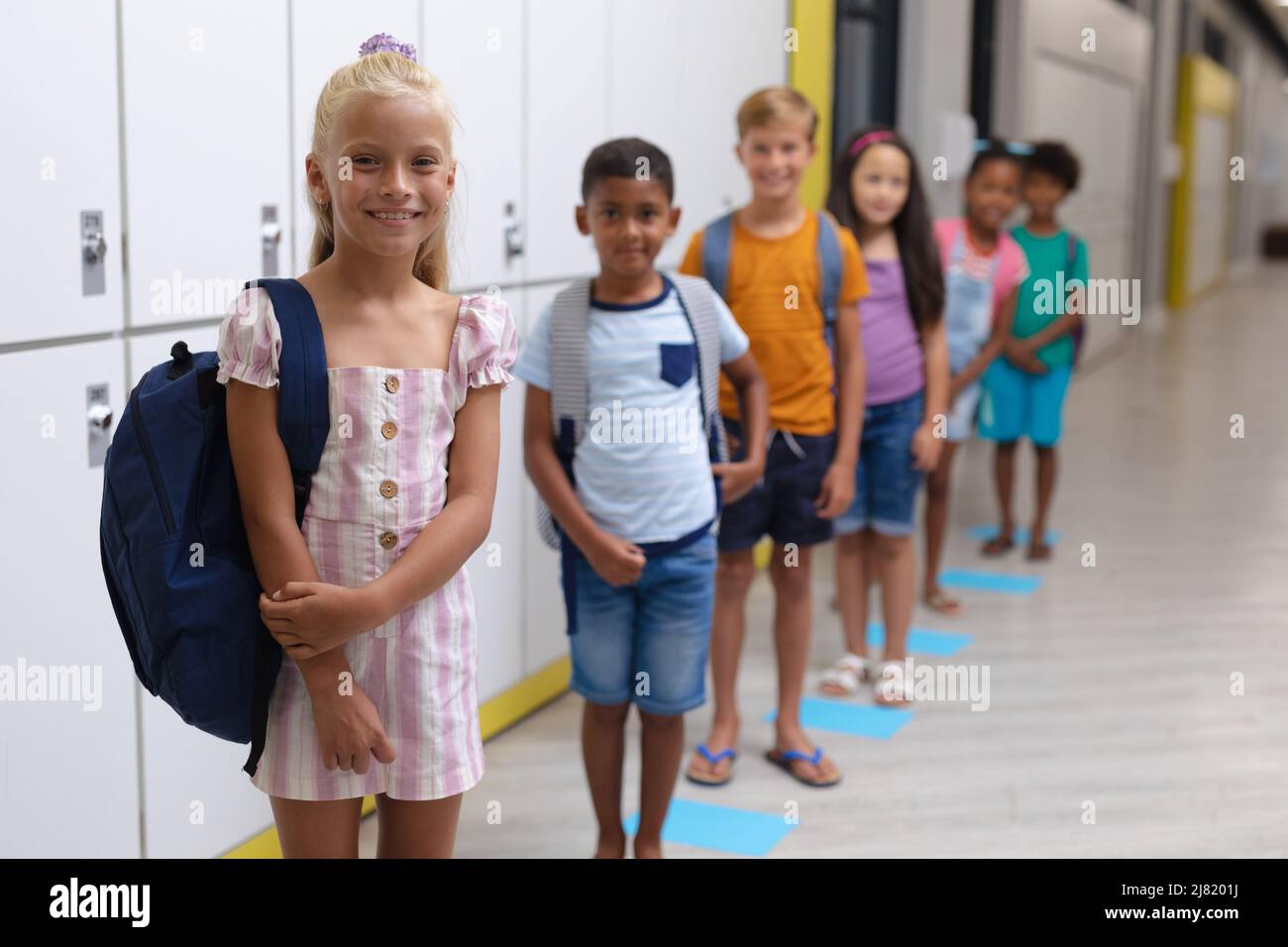 Portrait of smiling multiracial elementary school students standing in ...