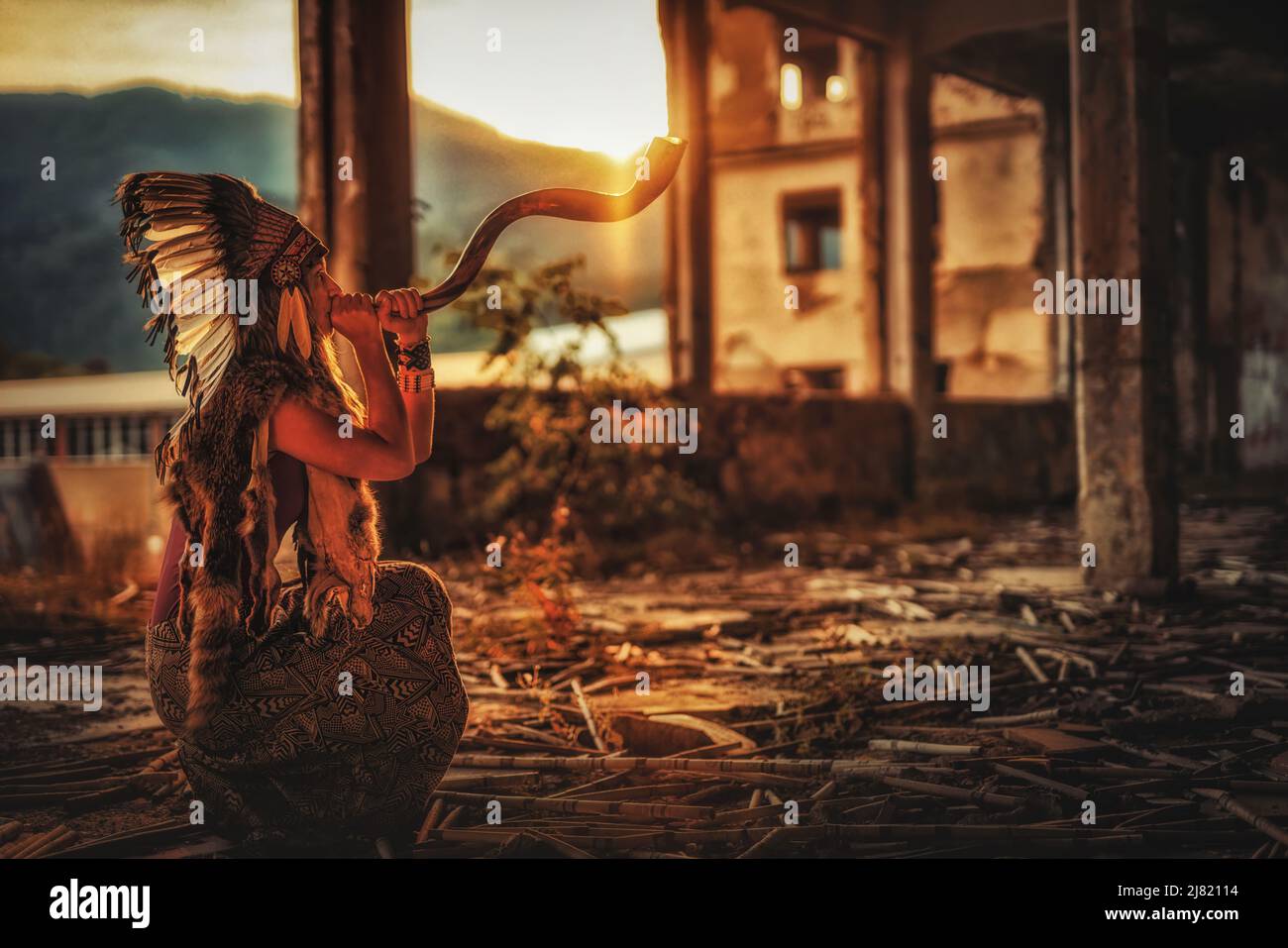 beautiful shamanic girl playing on shofar in the old industry building ...