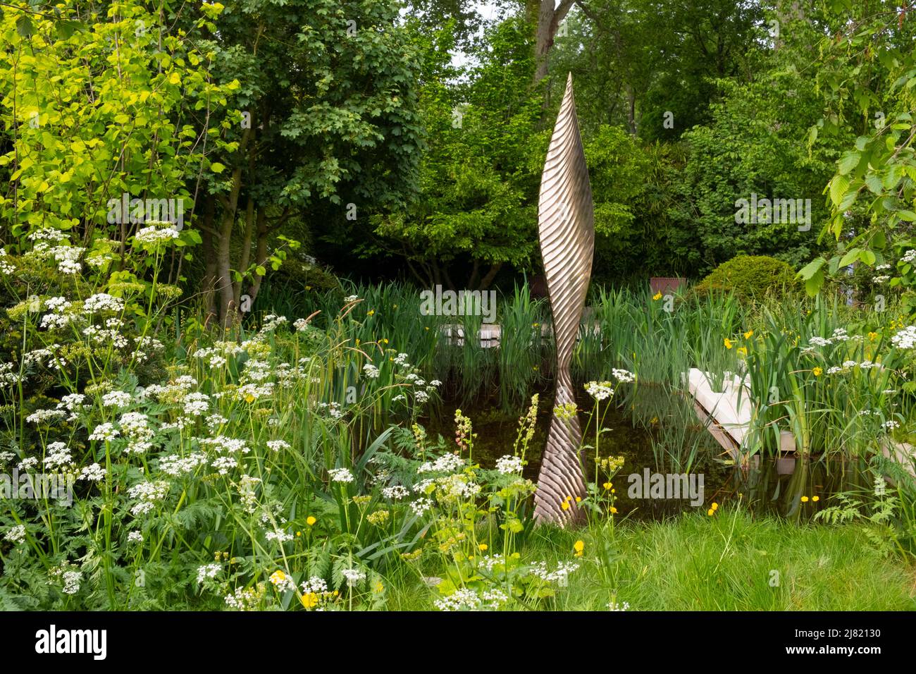 A central pool and sculpture surrounded by wild flowers in the Savills ...