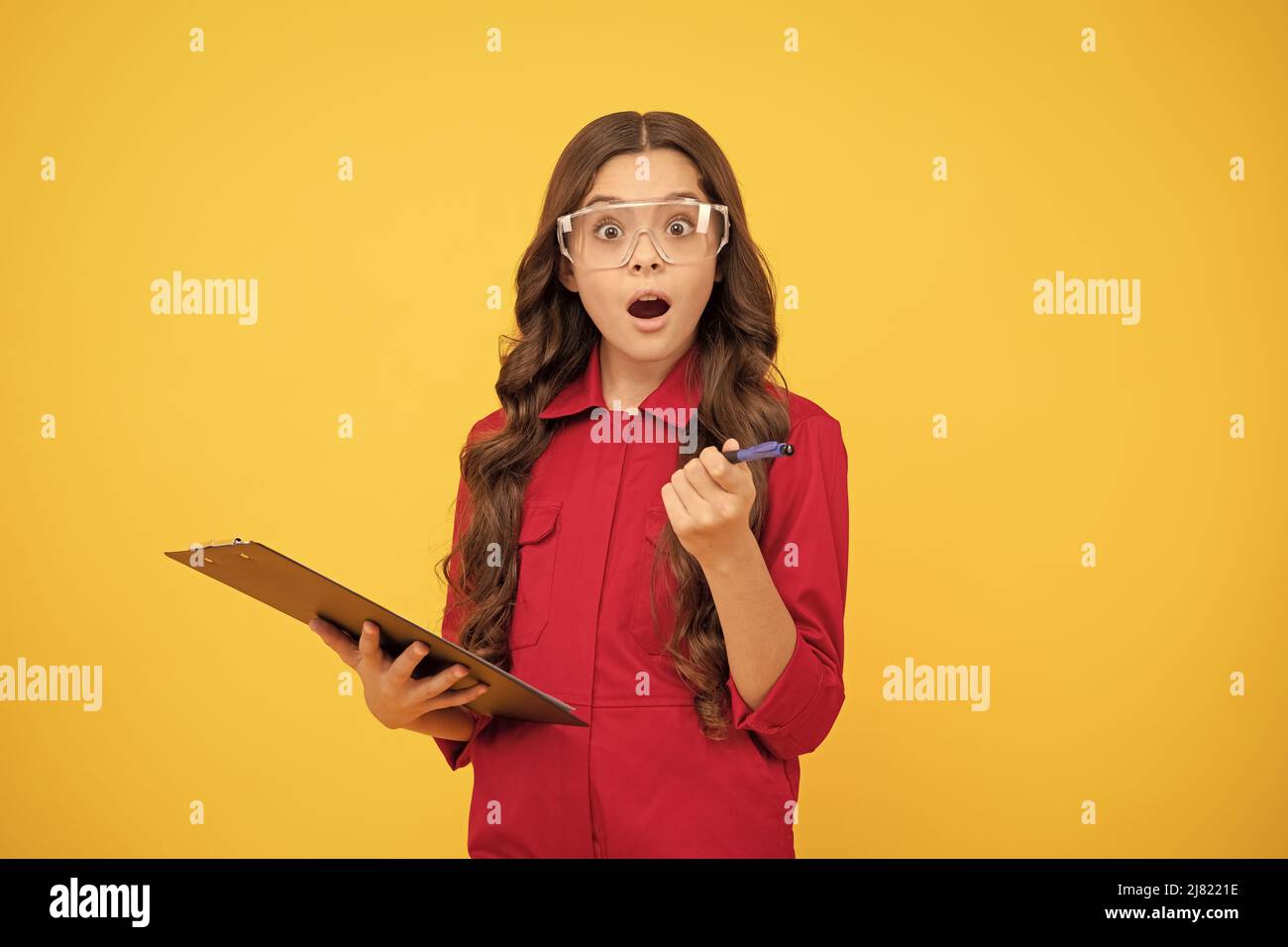 what a surprise. kid make notes in folder on yellow background. child ...