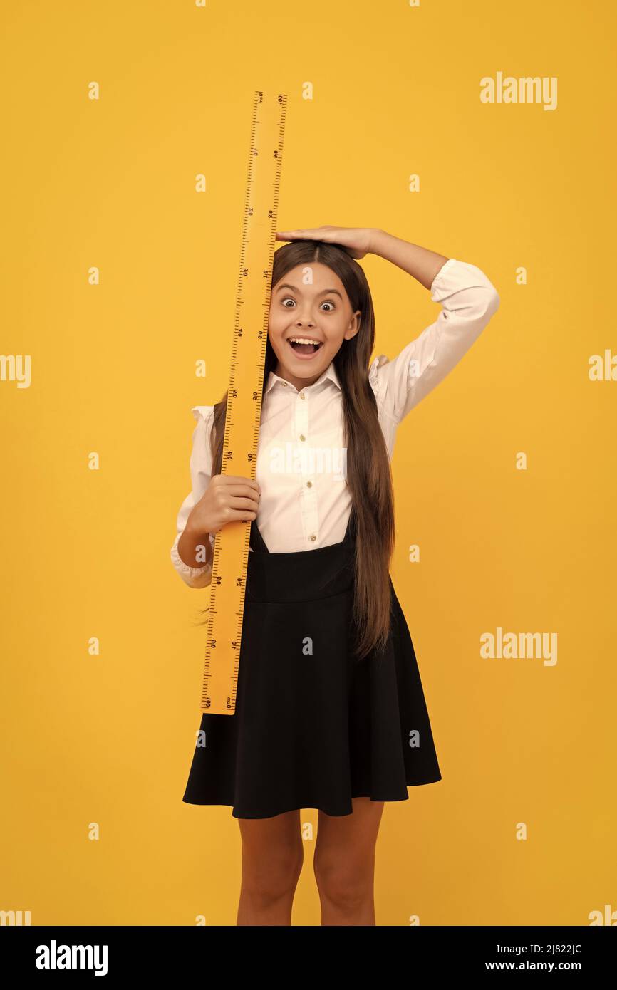 amazed child in school uniform hold mathematics ruler for measuring ...