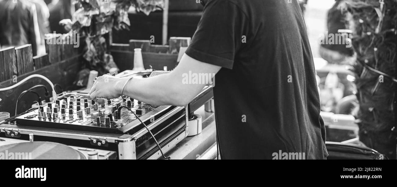 Dj playing music at cocktail bar outdoor - Focus on left hand - Black ...