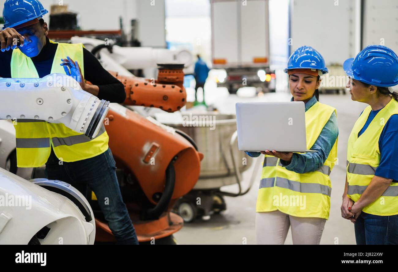 Multiethnic engineers working inside robotic factory - Industrial and ...