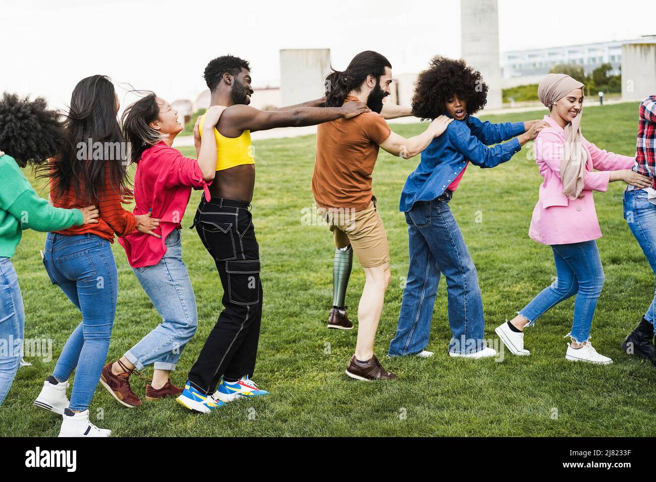 Young diverse people having fun dancing together outdoor at city park ...