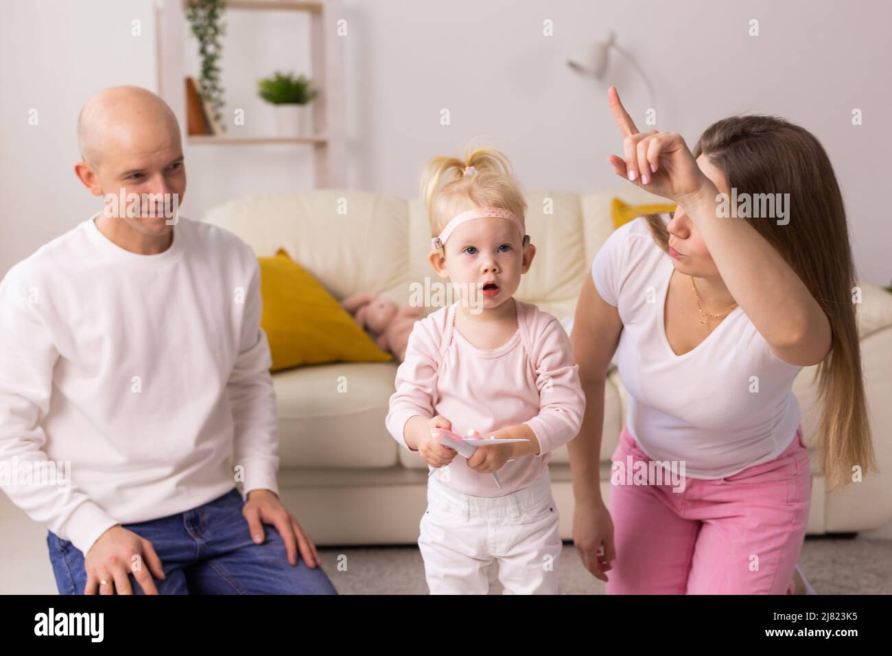 Cochlear implant on the child girl head and playing with mother and ...