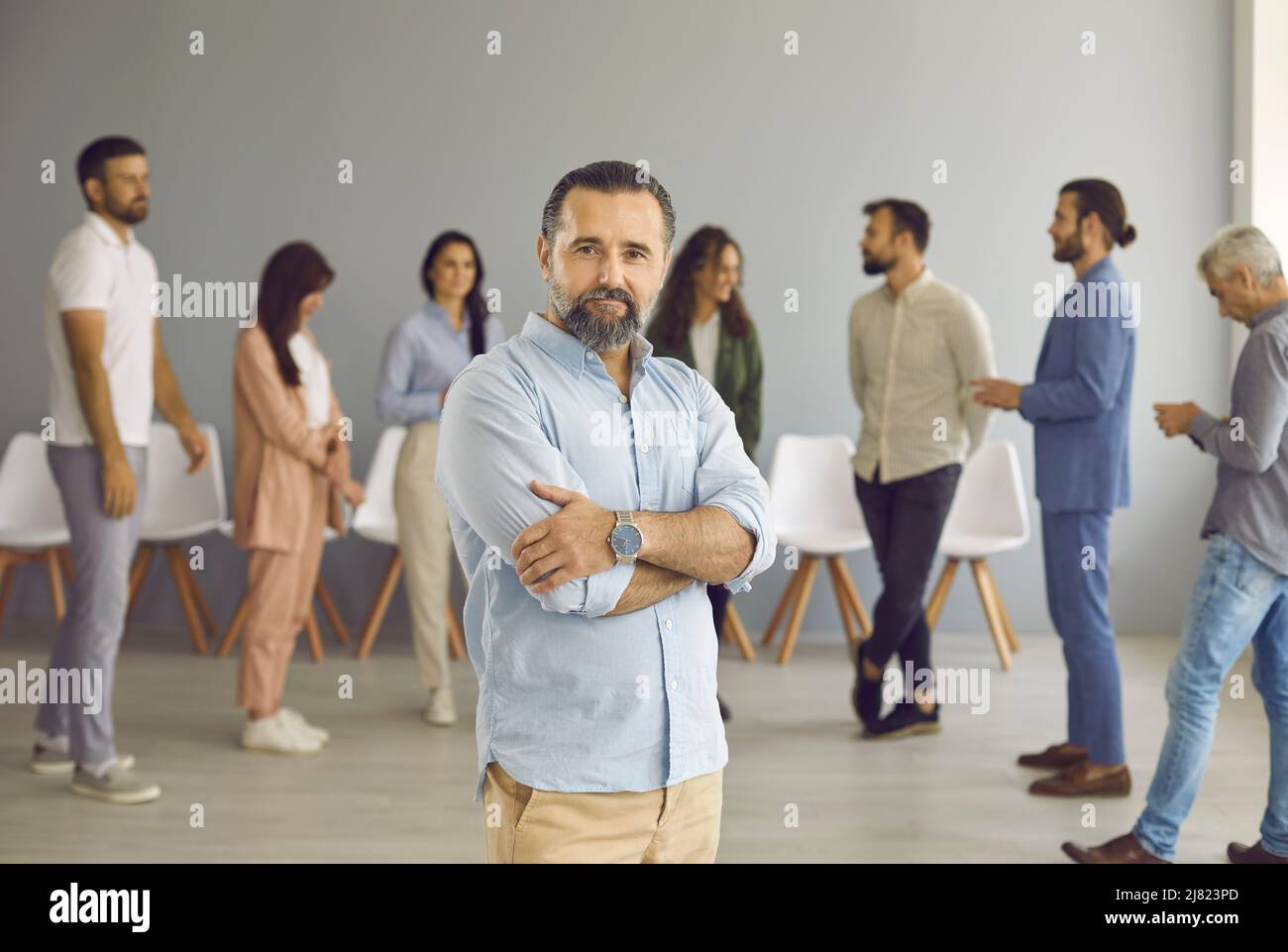 Portrait of a confident adult man standing against the background of ...
