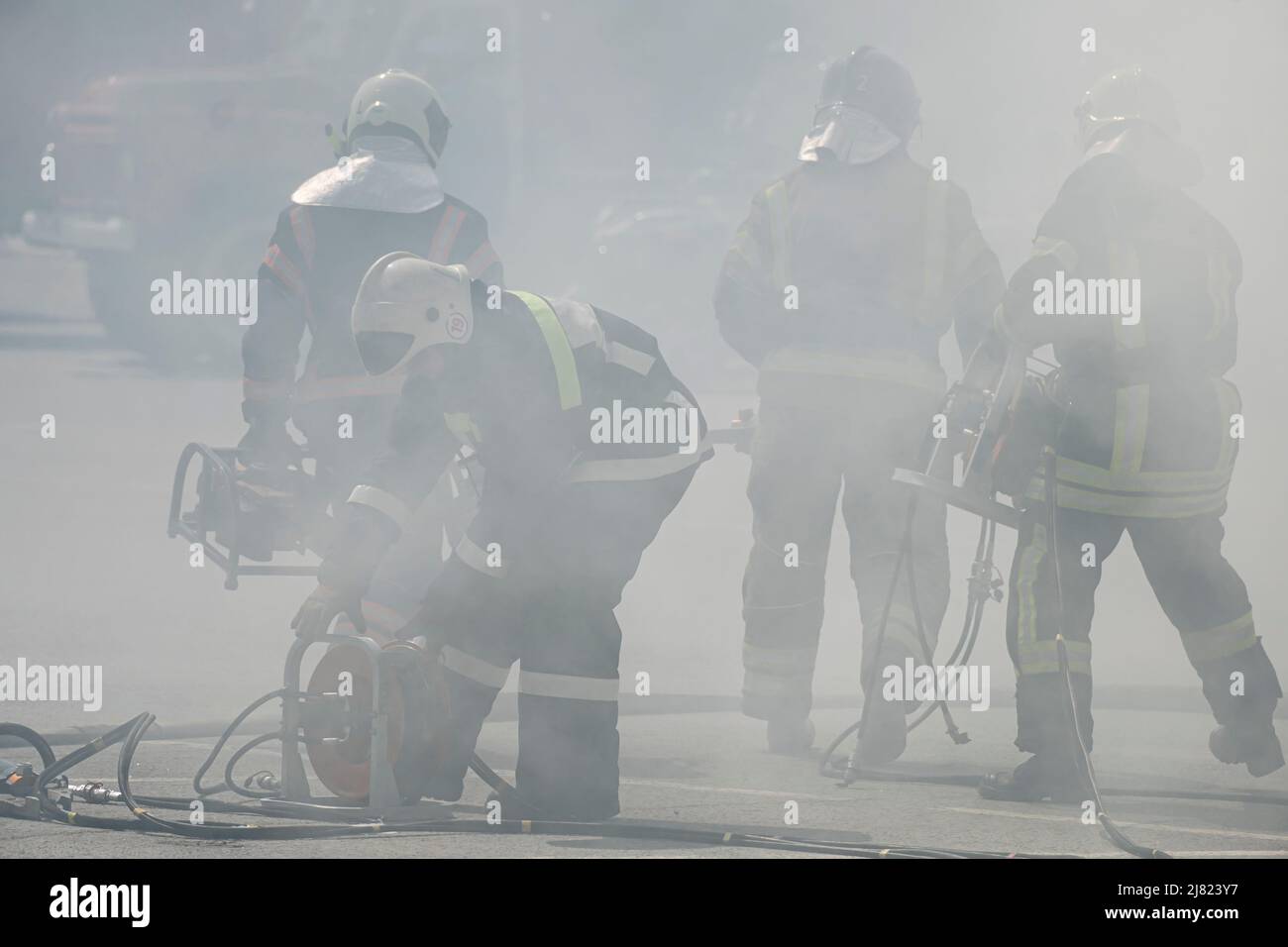 Firefighters men at action, running through smoke. A team of ...