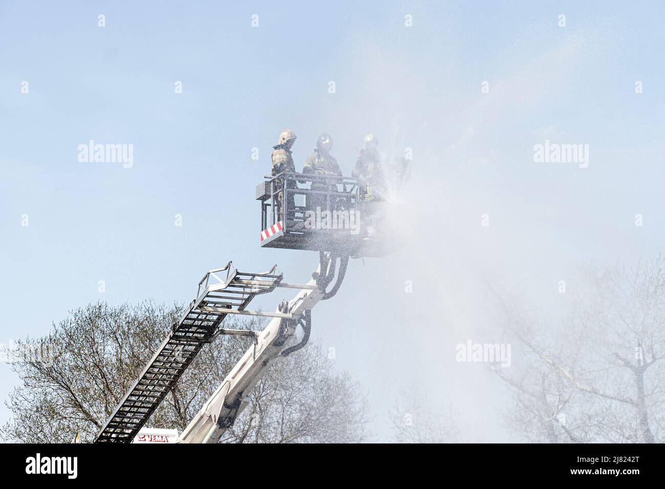 Firefighter works on boom of fire engine. Fireman on sky background ...