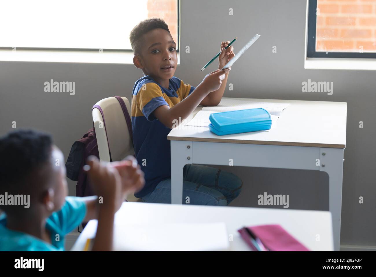 Portrait of african american elementary schoolboy with pencil and ruler ...