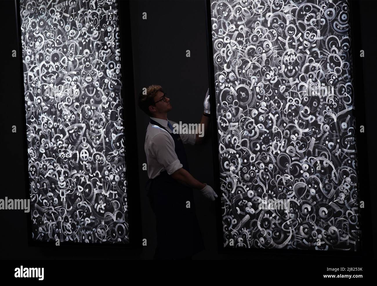 An art handler poses next to work on display at Sotheby's in London ...