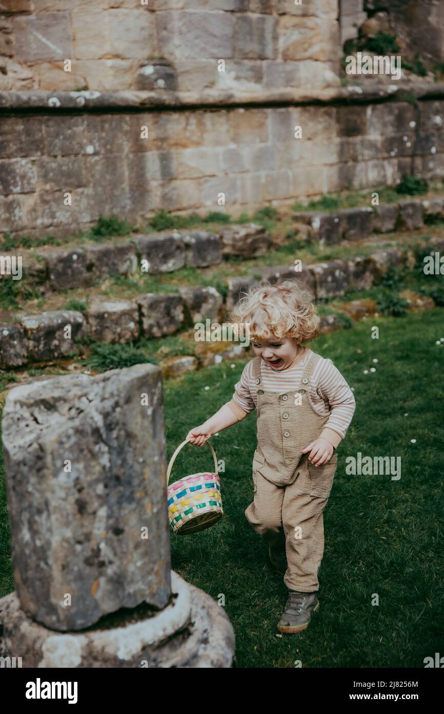 Boy toddler easter egg hunt outdoors cute Stock Photo - Alamy