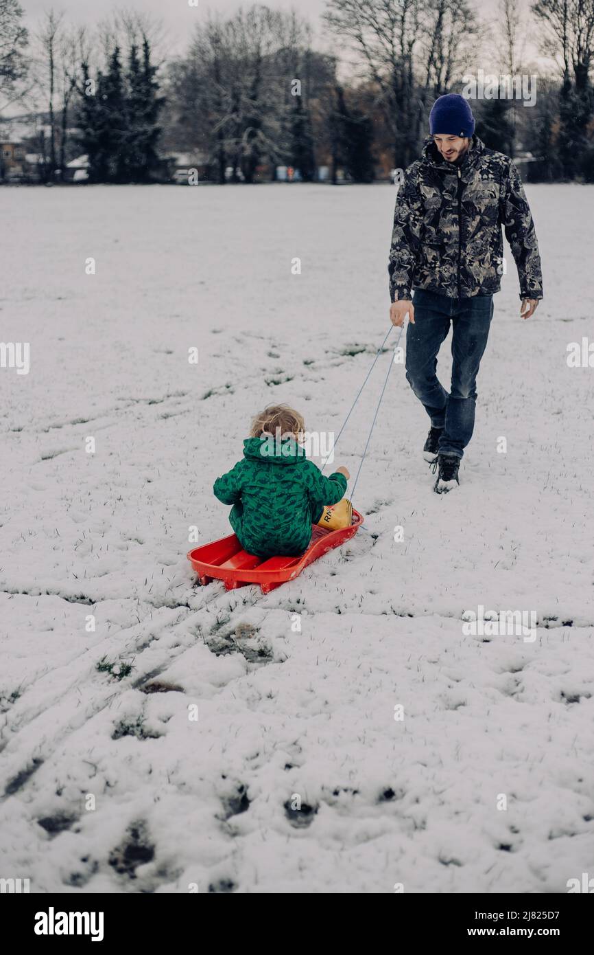 Happy Child family sledging in the snow UK Stock Photo - Alamy