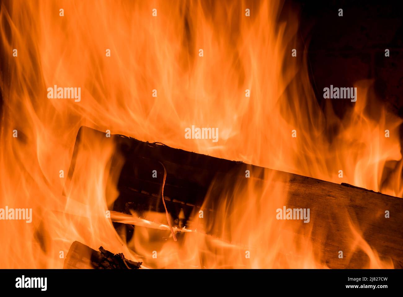Crest of flame on burning wood in fireplace Stock Photo - Alamy