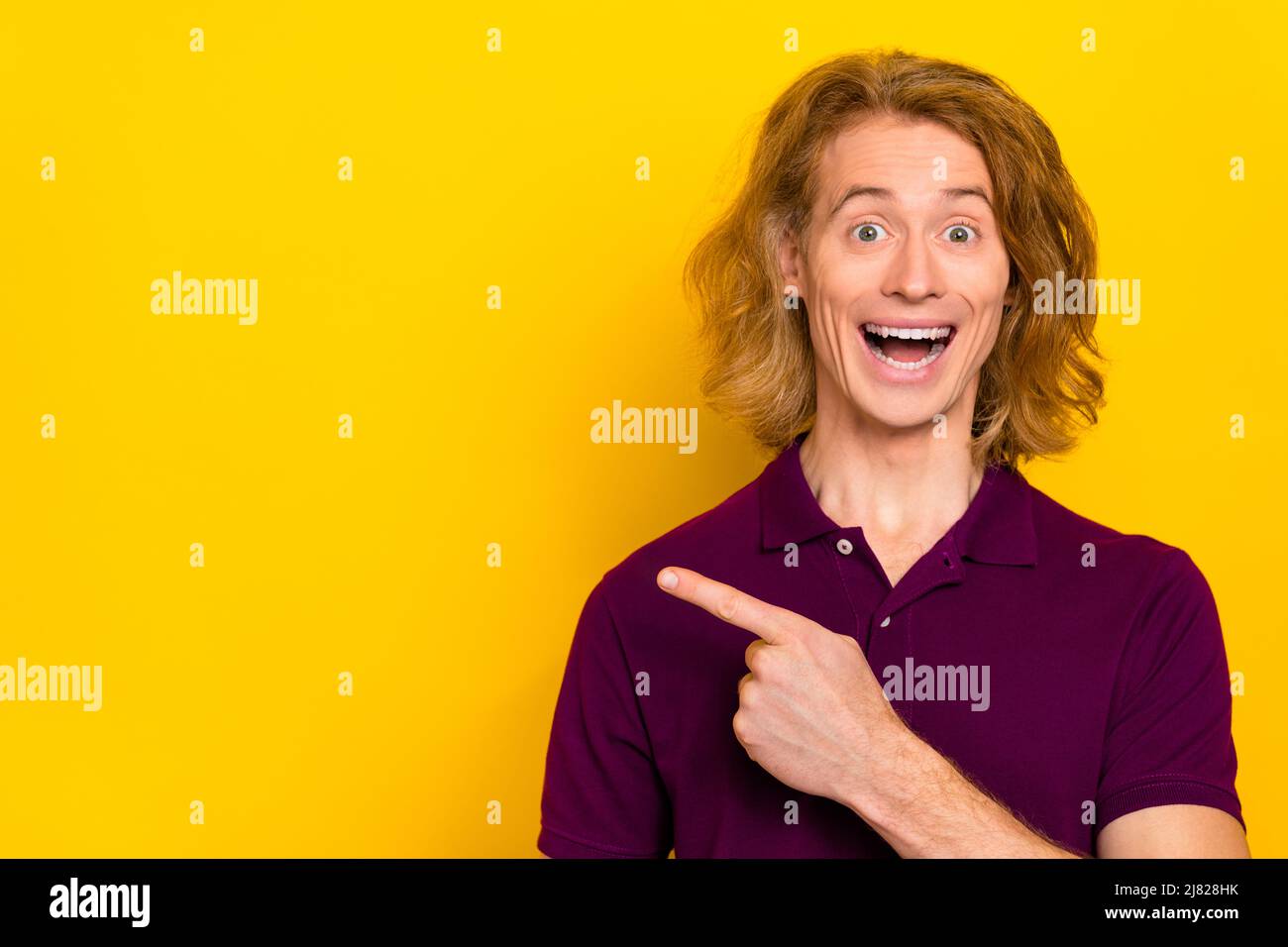 Photo of impressed millennial ginger guy indicate promo wear purple ...