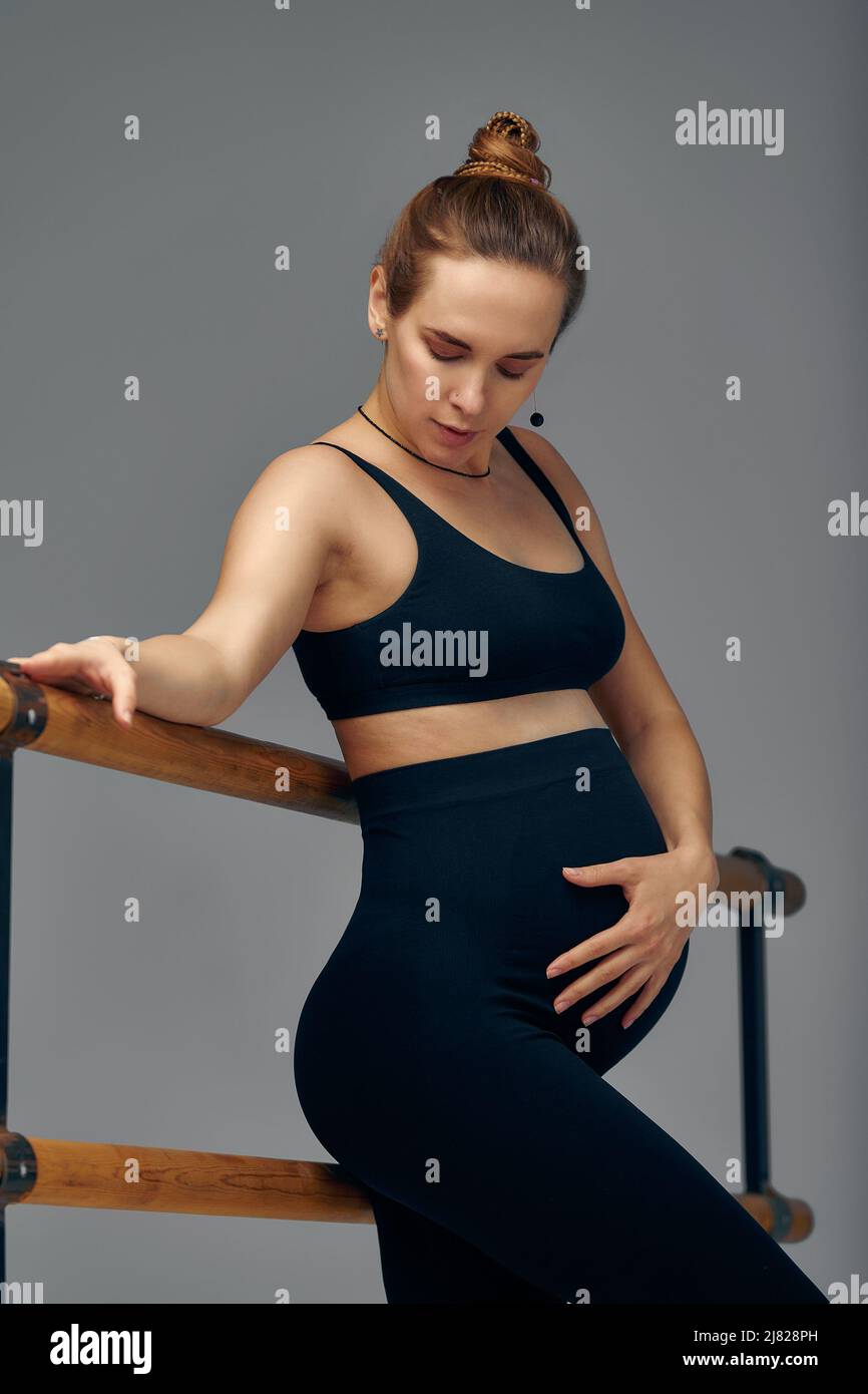 Cute pregnant belly isolated on gray. Side view of young pregnant woman ...