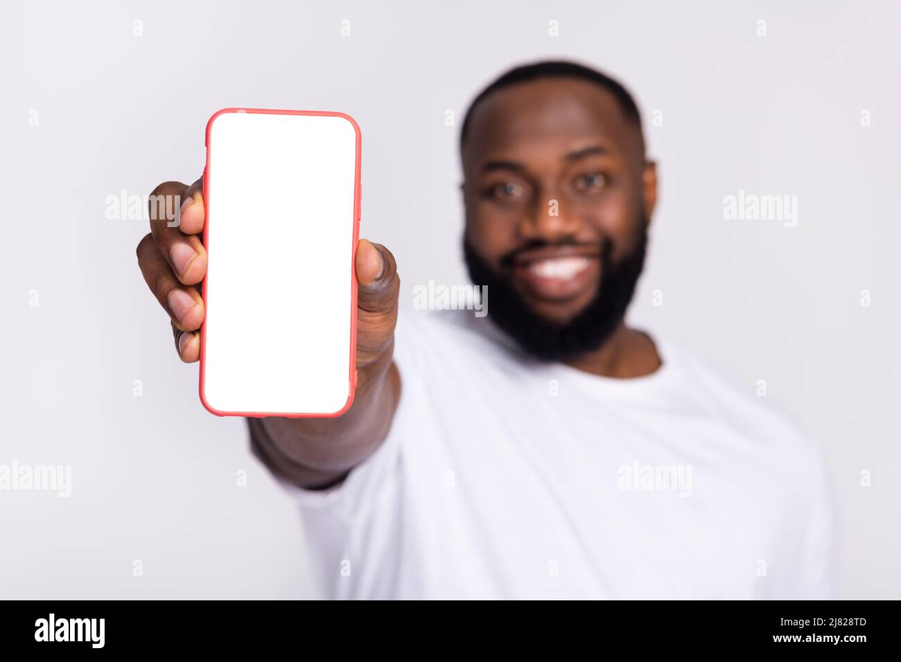 Photo of funny funky guy dressed casual t-shirt showing modern device ...