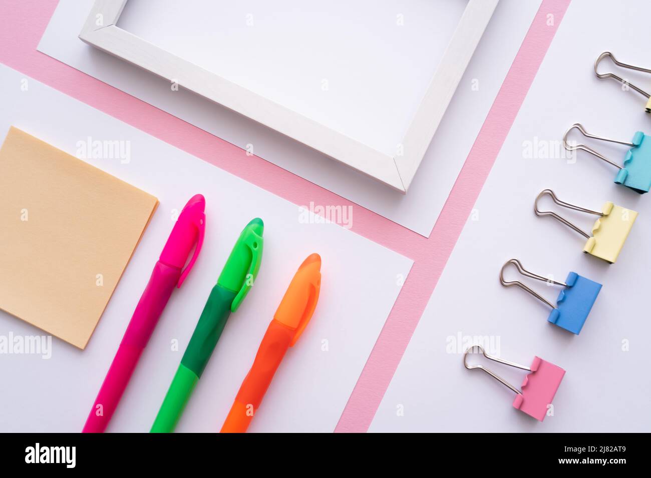 flat lay of colorful stationery near blank frame and white papers on ...