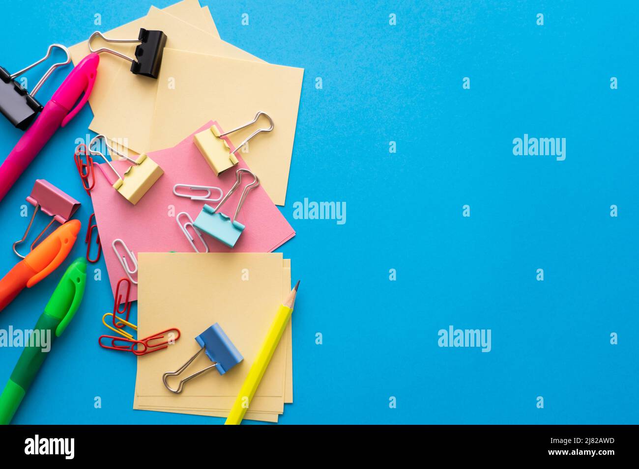 top view of colorful paper clips and fold back clips on paper notes on ...