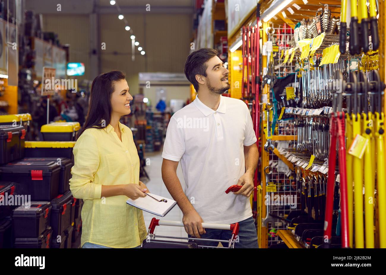 Happy married couple chooses variety of tools and materials for repairs ...
