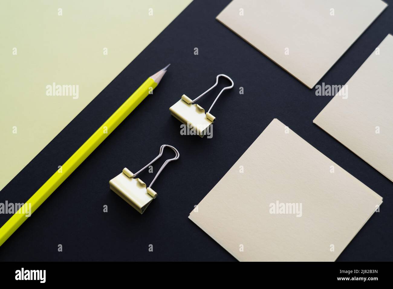 flat lay of blank paper near sticky notes, pencil and fold back clips ...